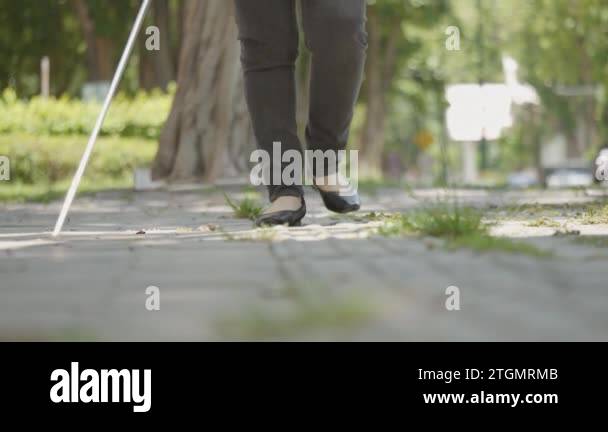 Woman with blindness disability walking on sidewalk contain tactile ...