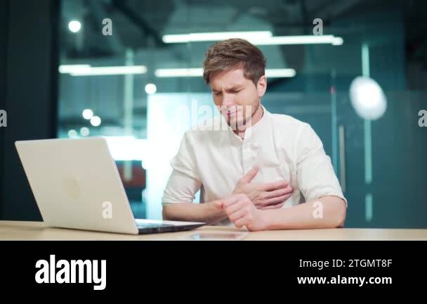 A young employee suffers a heart attack at the workplace. Feeling pain ...