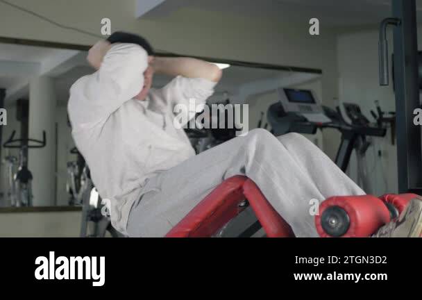 Sportsman trains abdominal muscles at the gym. Bodybuilder performs abs ...