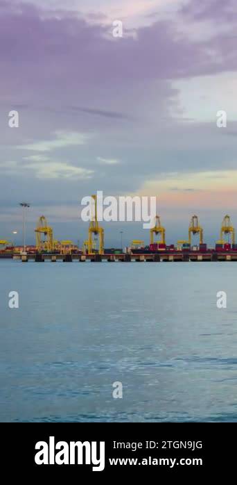 vertical timelapse of deep sea port with cargoship loading and ...