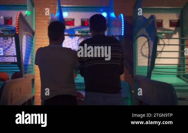 People back view Playing Basketball and Throwing Ball at Arcade Machine ...