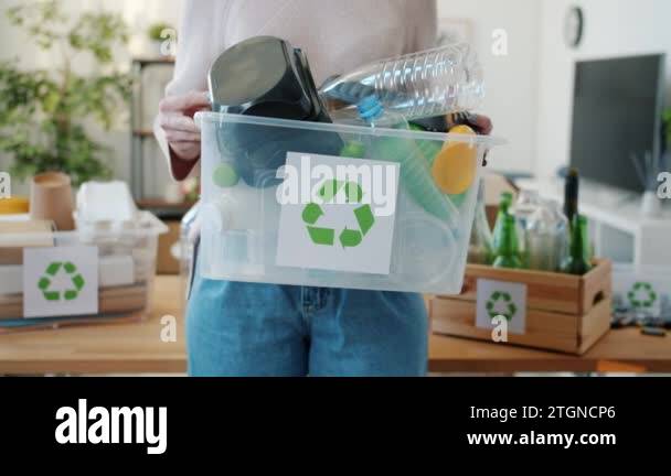 Close-up of full recycling box with plastic containers and woman ...