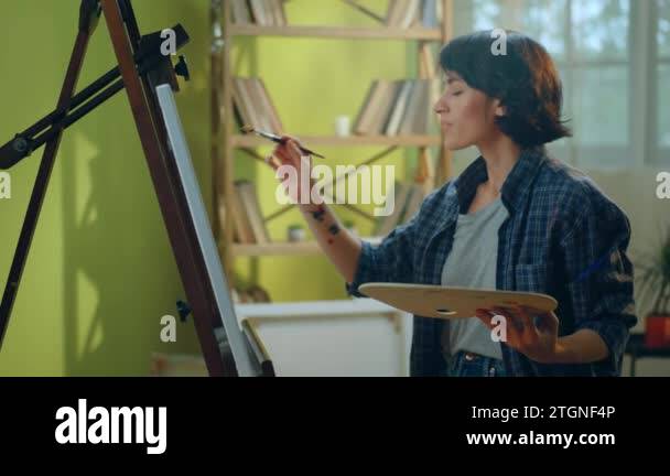 A beautiful woman who is an artist and has paint over her hands is ...