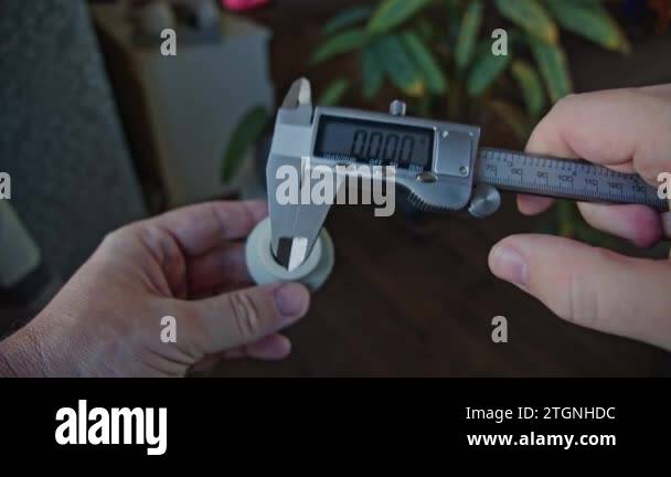Measuring metal piece with vernier caliper. Worker conducts defect ...
