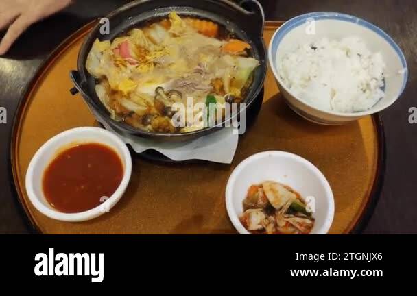 Each members of the dining table used chopsticks to grab food (pork ...