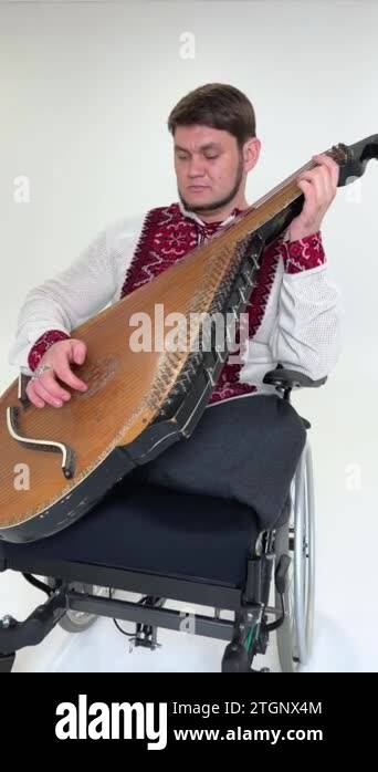 man in wheelchair plays musical instrument he has no legs in war he ...