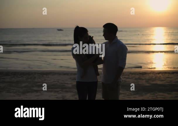 Tourism concepts of 4k Resolution. Silhouette of an Asian family relaxing on the beach Stock ...