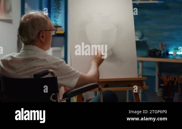 Male wheelchair user drawing vase design sketch on canvas, using ...