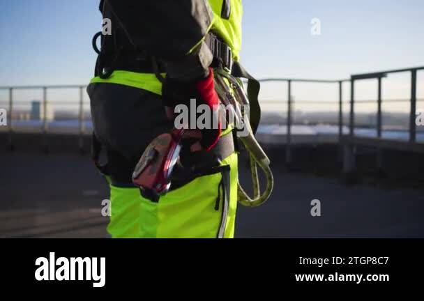 Close-up of an industrial climber unfastens the trigger device from the ...