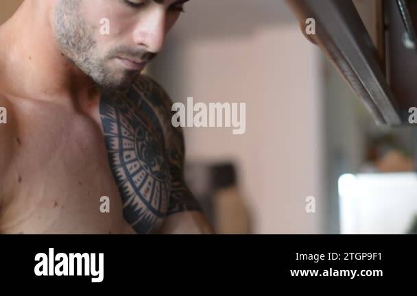 Shirtless male bodybuilder cooking in kitchen at home, preparing meal ...