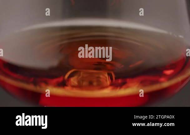 Luxury brandy and drop in glass of cognac. Glass with golden cognac on ...