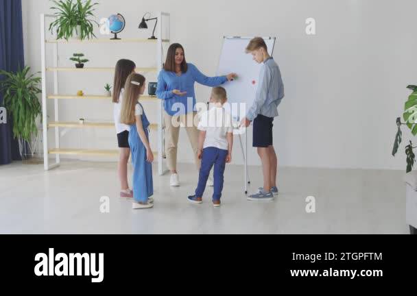 Explaining lesson and using board. Group of children students of ...
