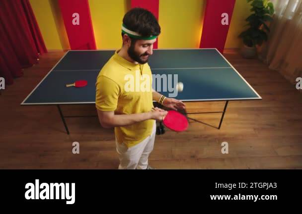 Good looking young man ping pong player catch and hitting the ball with ...