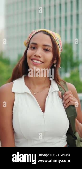 VERTICAL VIDEO: Cute tanned woman with long brown hair wearing white ...
