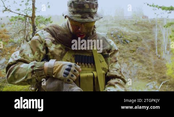Wounded mercenary soldier with a blood on the face looking at camera ...