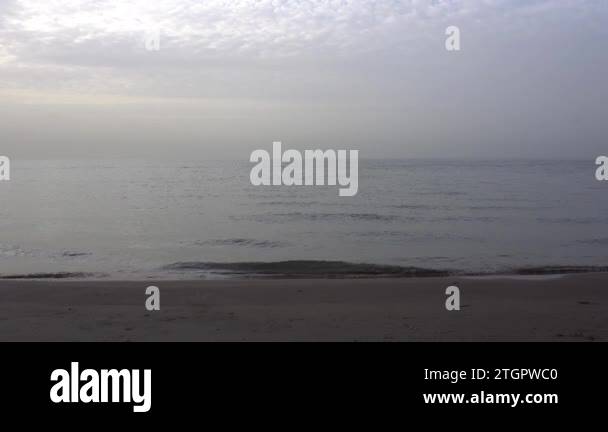 Dawn on the sandy beach of the sea. Sand dune. The suns rays peek out ...
