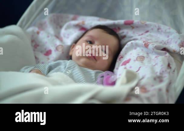 Beautiful newborn girl rides in a rocking chair. The baby in the swing ...