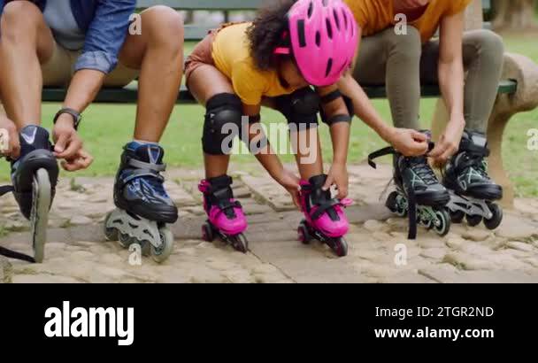 Close up on the feet of an active fun family in a park tying or putting ...