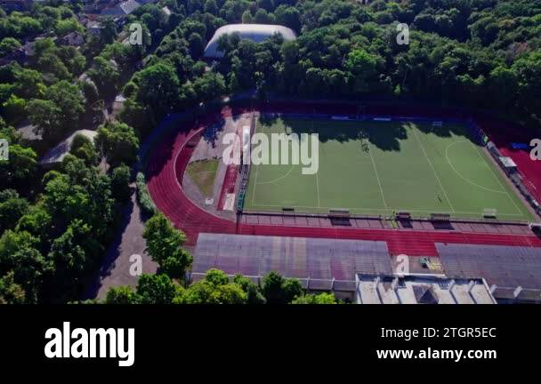 Buildings with street in small town with empty football soccer field ...
