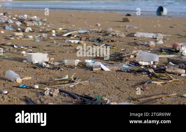 Plastic pollution on the sea beach. Waste at high tide with ocean waves ...