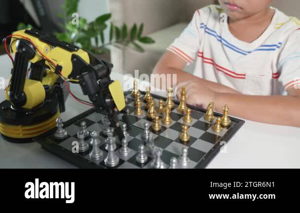 Asian little boy thinking and wait robot arm playing chess, STEM ...