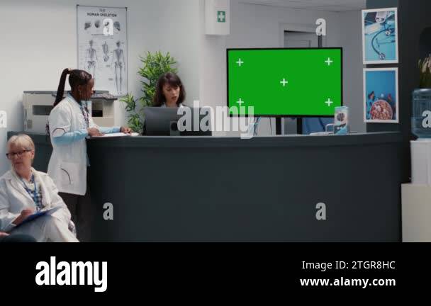 Hospital reception desk with greenscreen on tv monitor in waiting room ...