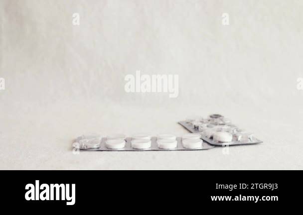 Used medicine blister pack with white and red pills falling from top ...