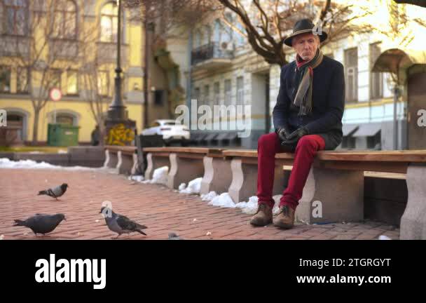 Wide shot portrait of frustrated lonely senior Caucasian man sitting on ...