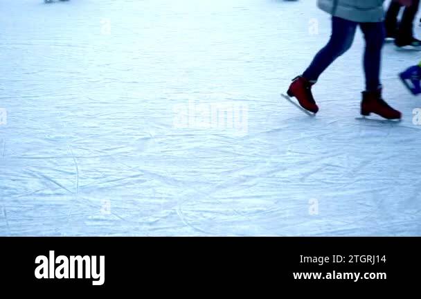 Ice skating rink in winter. People are skating. Skates ride on ice. Ice ...