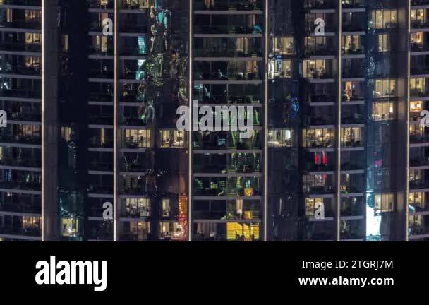 Illuminated panoramic windows in apartments of a high class building at ...