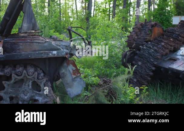 Close-up parts of destroyed military vehicles with suburban road and ...