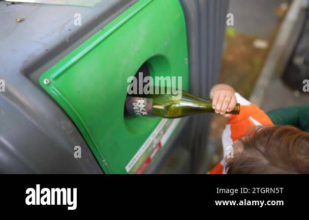 Child recycling glass bottle into recycle bin dispenser. Kid putting ...
