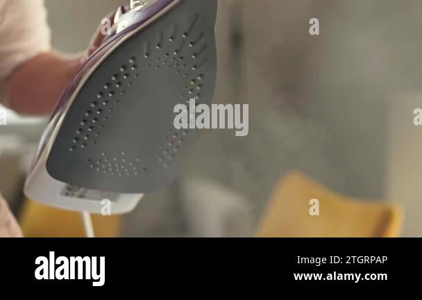 Girl hand holding iron with steam mode closeup. Woman with hot electric ...