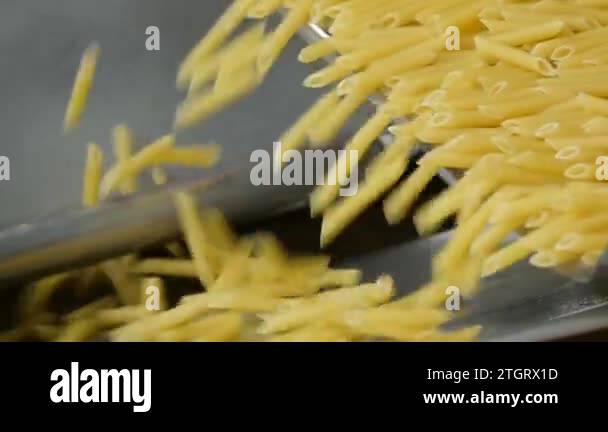 Macaroni factory. Production cycle of making pasta. Pasta is pouring ...