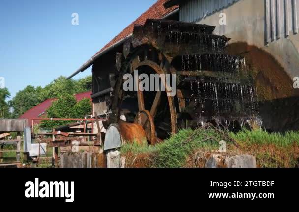 Rotating water mill. Old wooden water mill. Mill wheel rotating under ...