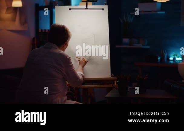 Old woman with creative skills drawing professional artwork with vase ...