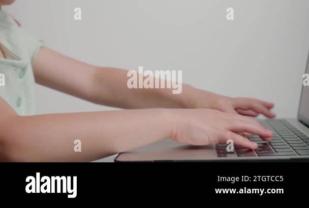 Hands of little girl push buttons on keyboard of laptop. Schoolchild ...
