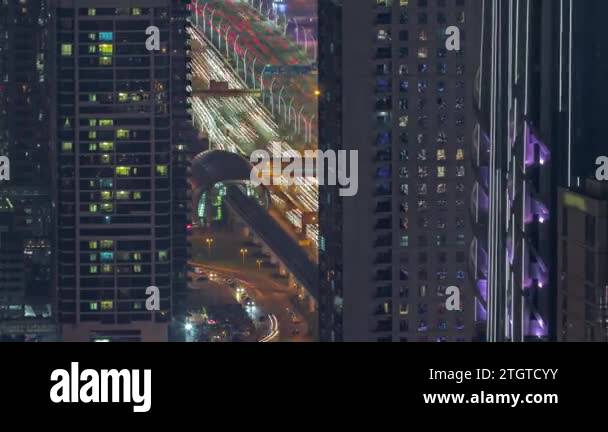 Highway and overpass between skyscrapers with glowing windows in Dubai ...