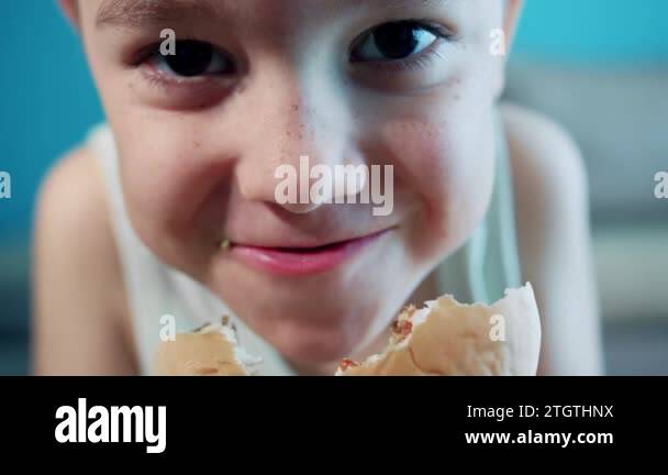 Little boy in fast food cafe eats burger. Portrait of hungry child Cute ...