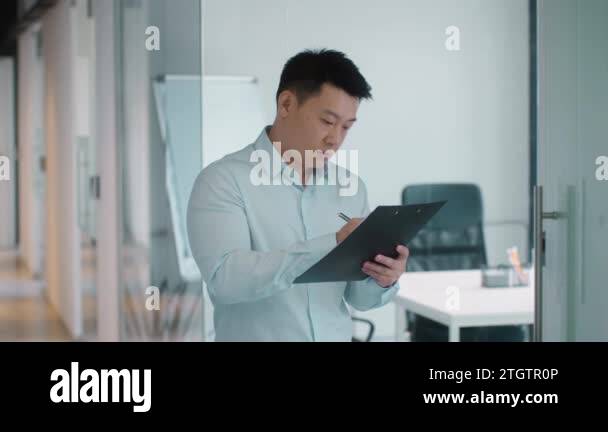 Professional middle aged asian man auditor making inventory at ...