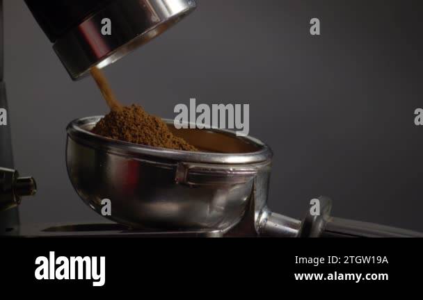 Preparing ground coffee in electric grinder close up. Aromatic powder ...