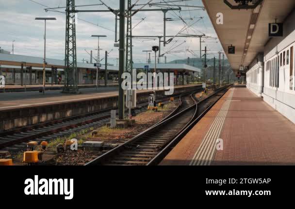 Empty railway station platform along tracks. Empty train station ...