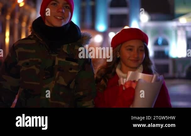 Dolly shot portrait of romantic teenage couple talking strolling ...