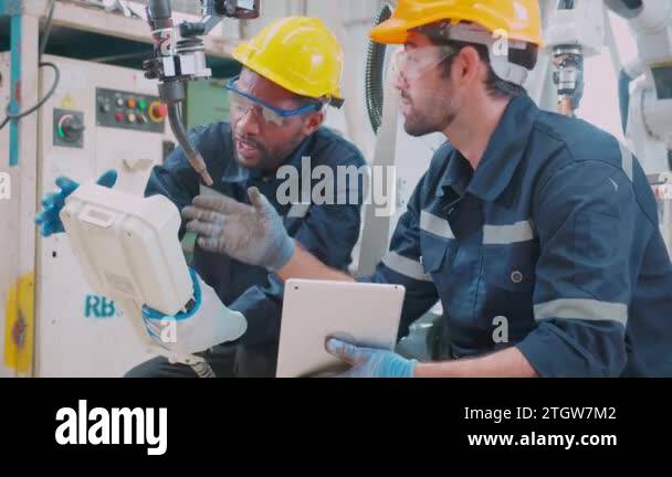 Two young engineer man talking and explaining about robot arms ...