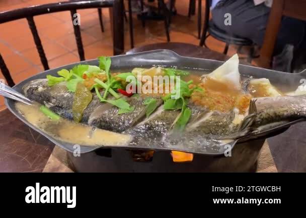 Thai style garlic lime steam sea bass barramundi fish on hot fish ...