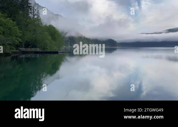 Completely still, beautiful reflecting water with a wooden dock, low ...