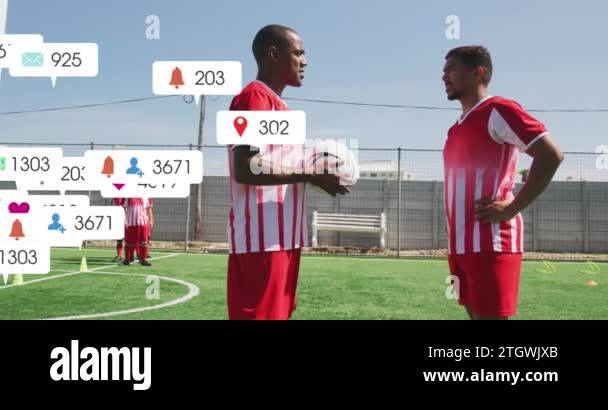 Social media icons over two diverse male soccer players talking to each ...