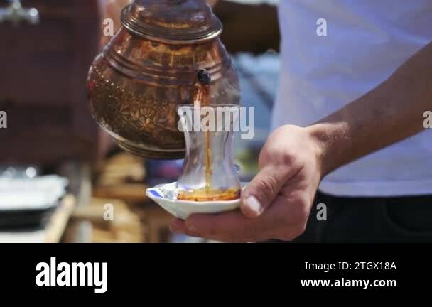 Traditional Turkish tea being poured into a traditional Turkish tea glass. Slow motion in 4K ...