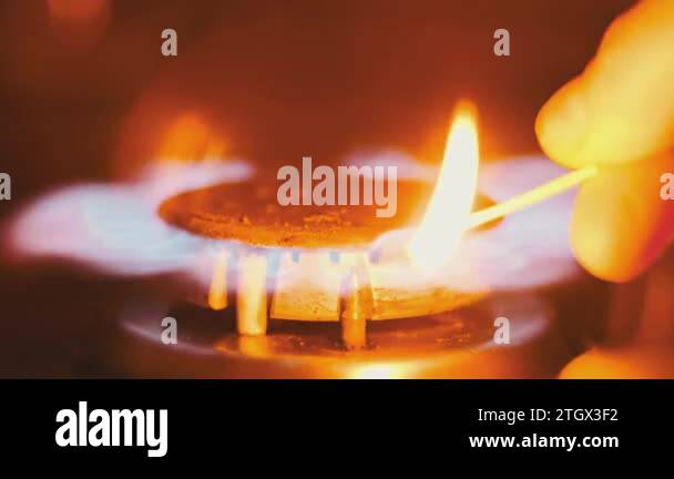 Ignite the gas on the stove with a matchstick, close-up. Manual ...