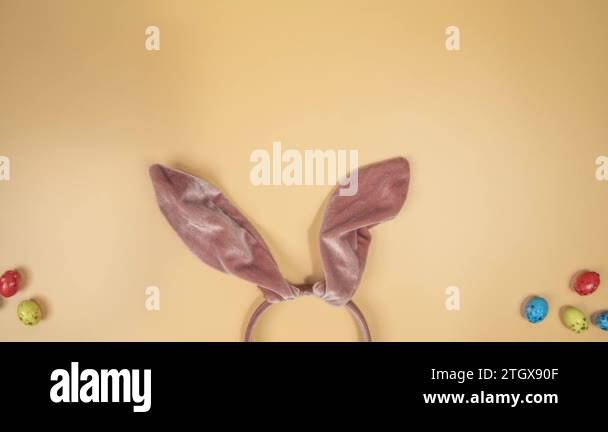 Movement of multicolour Easter eggs on a orange background with bunny ...